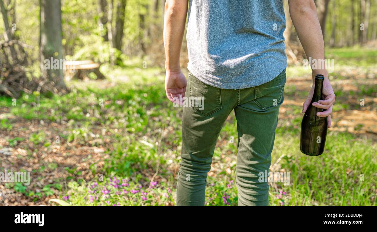 man with a bottle of alcohol in the woods. Solving the problem of ...