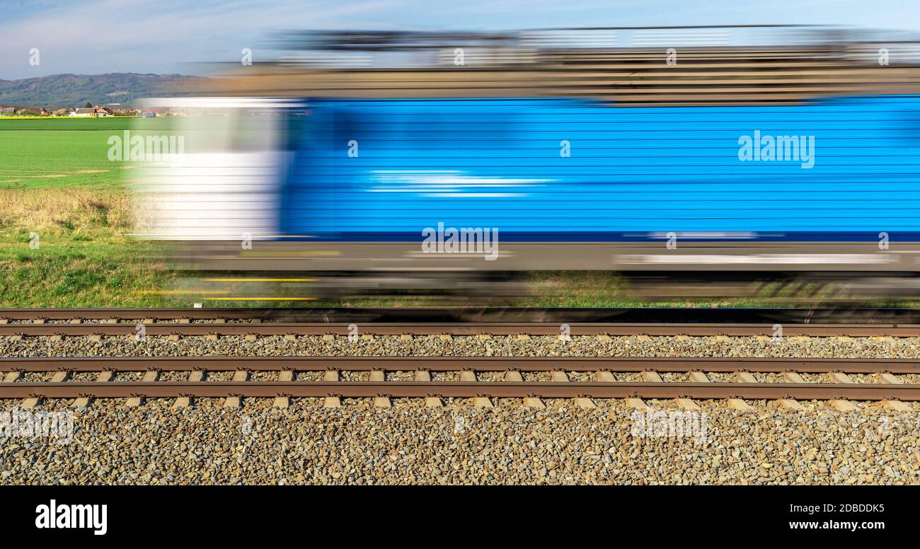 Blue train powered by electricity, drives through the countryside ...