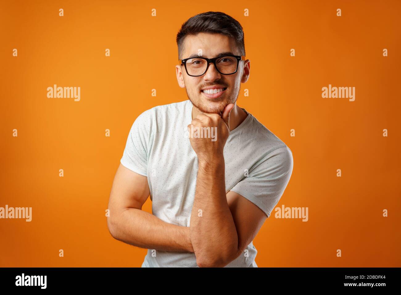 Young positive man in white casual shirt standing with happy smile ...