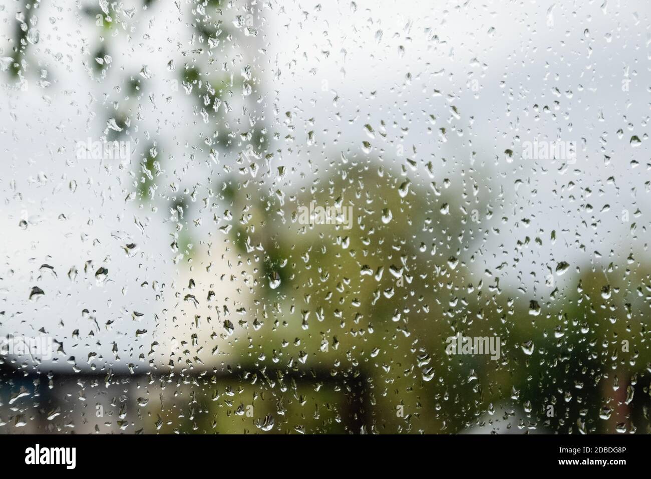 Raindrops on the window pane. Blurred background outside the window in ...