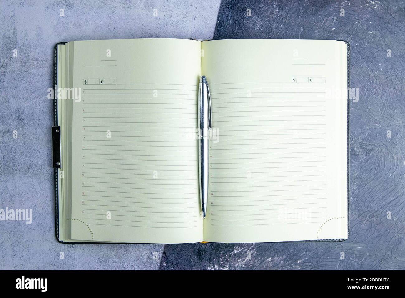 Open net note pad with a pen on a gray table. Top views with clear ...