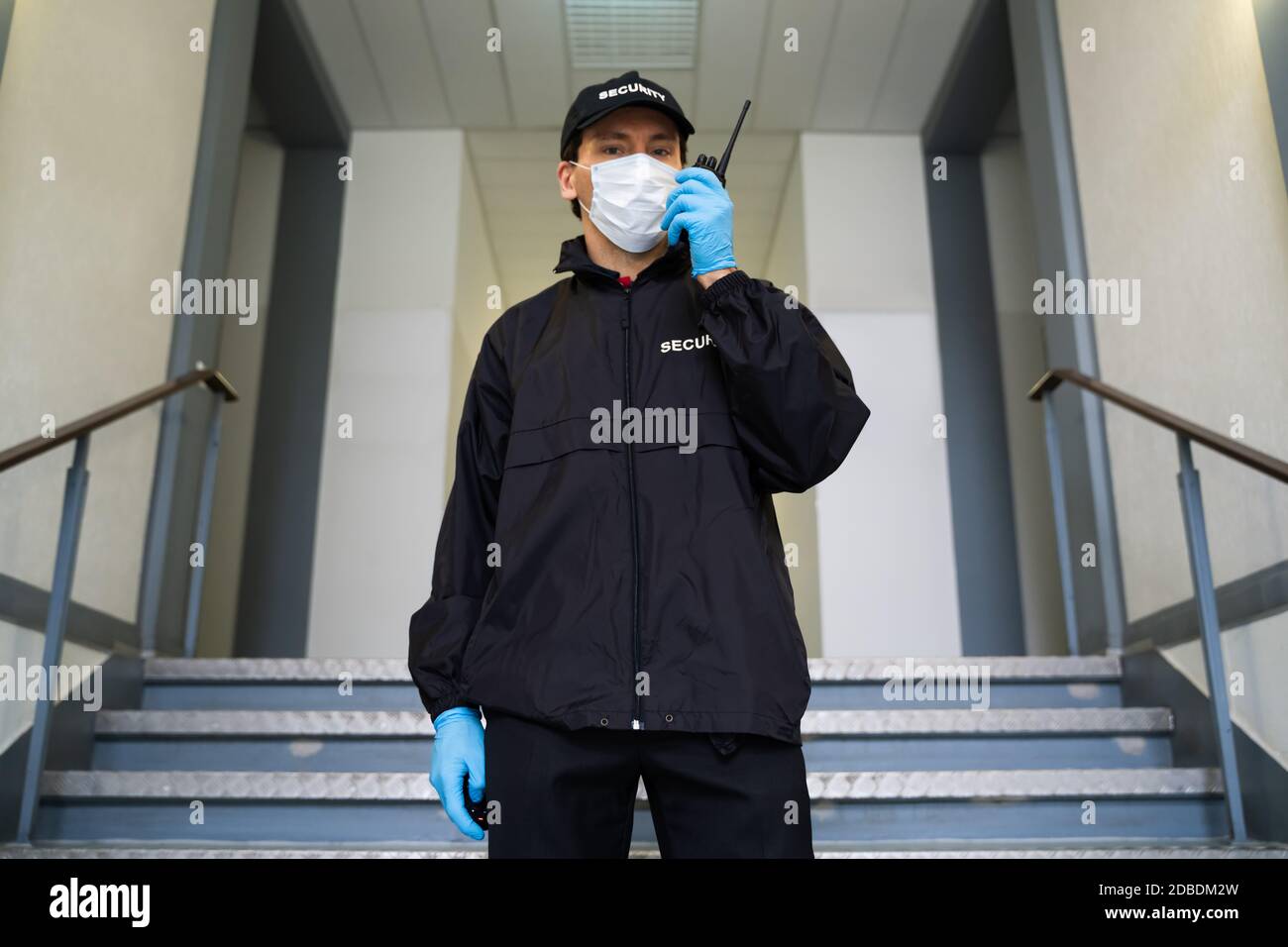 Security Guard In Face Mask Talking On Walkie Talkie Stock Photo - Alamy