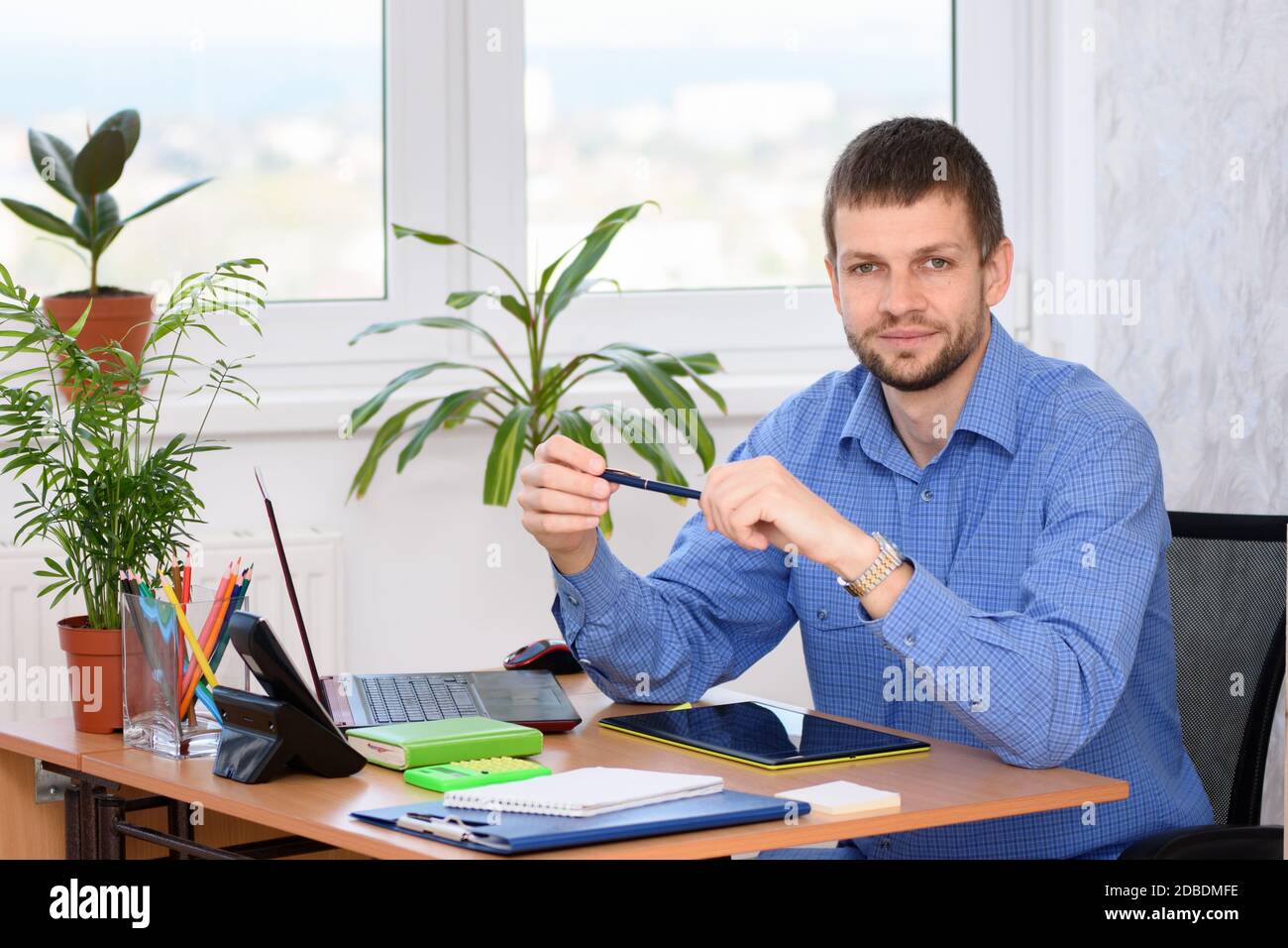 Portrait of an office specialist at a desk in an office Stock Photo - Alamy