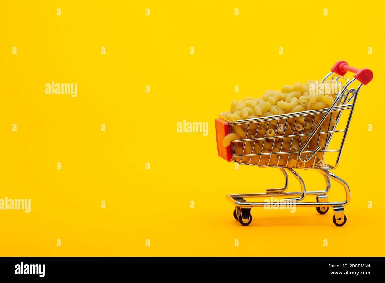 Grocery trolley filled with pasta on a bright orange background Stock ...