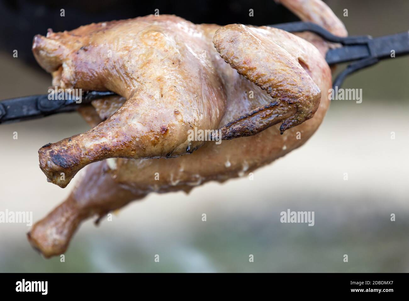 Whole chicken being roasted on an open fire Stock Photo - Alamy