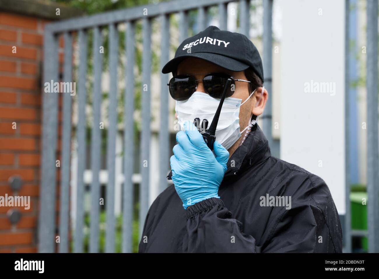Security Guard In Face Mask Talking On Walkie Talkie Stock Photo - Alamy