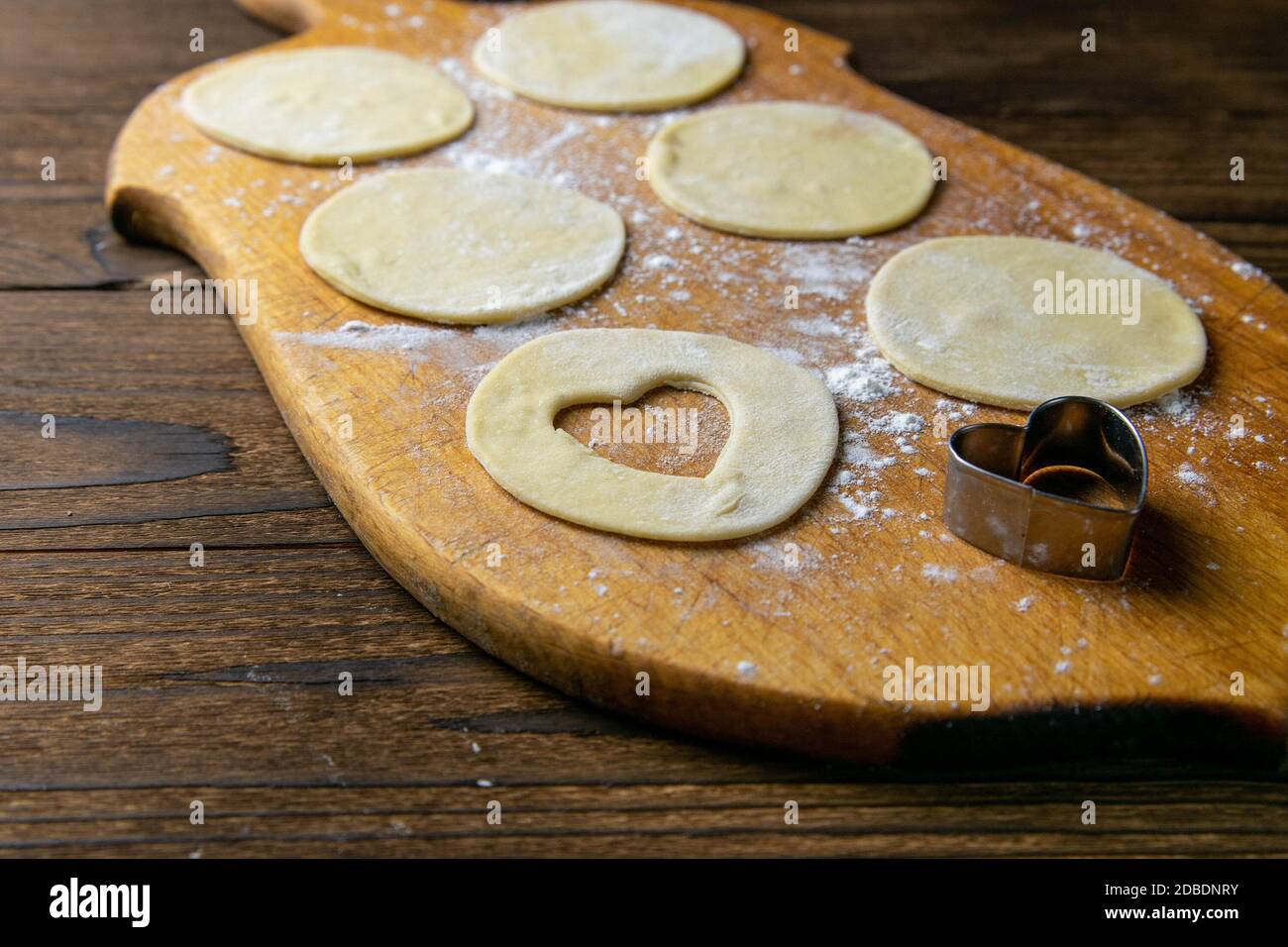 Heart shaped dumplings, flour on wooden background. Cooking dumpling ...