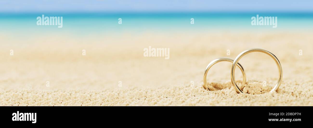 Gold Wedding Rings In Sand On Beach Stock Photo - Alamy
