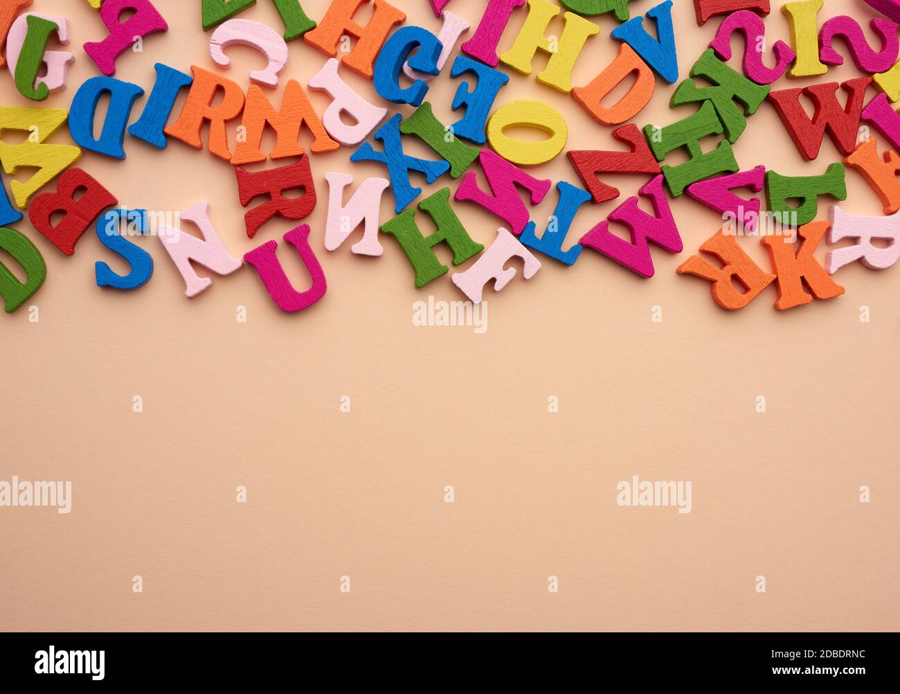 multi-colored wooden letters of the English alphabet on a beige ...