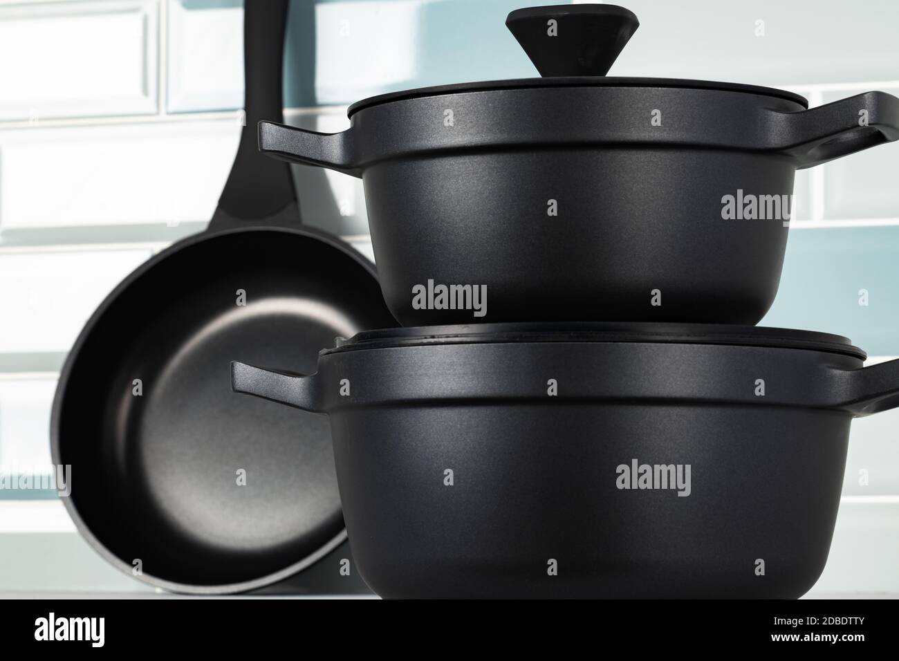 Set of black cookware on kitchen counter Stock Photo - Alamy