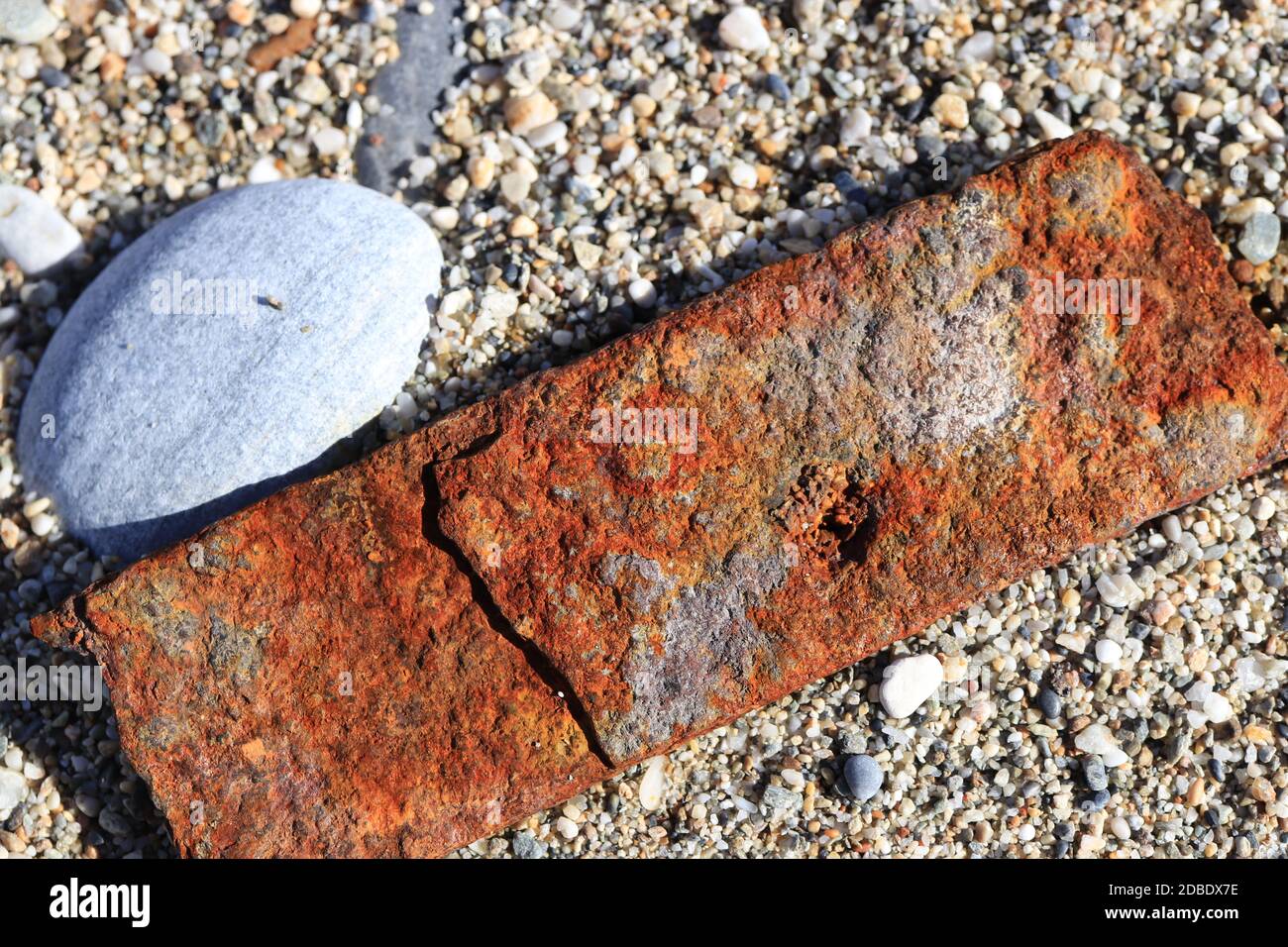 Rusty metal plate with stone lying on the sand Stock Photo - Alamy