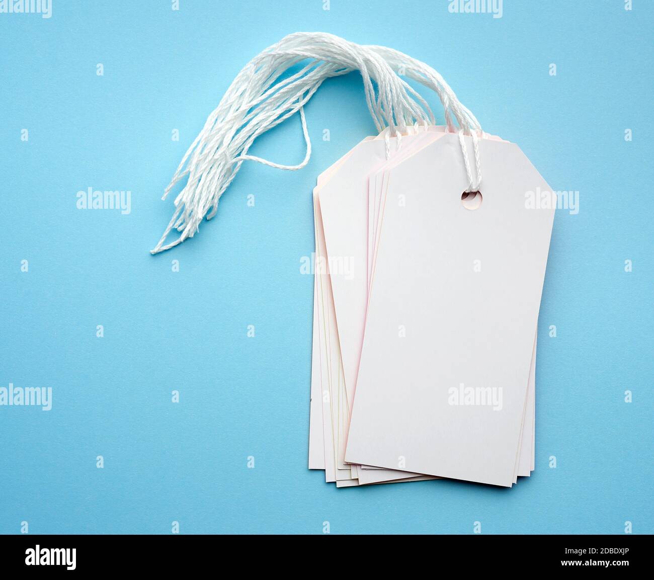 stack of empty white rectangular paper tags on a rope, blue background ...