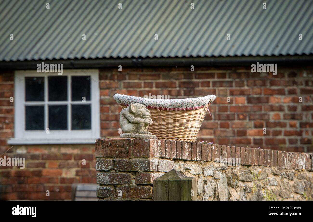A stone gargoyle and wicker basket on a stone and brick wall Stock ...