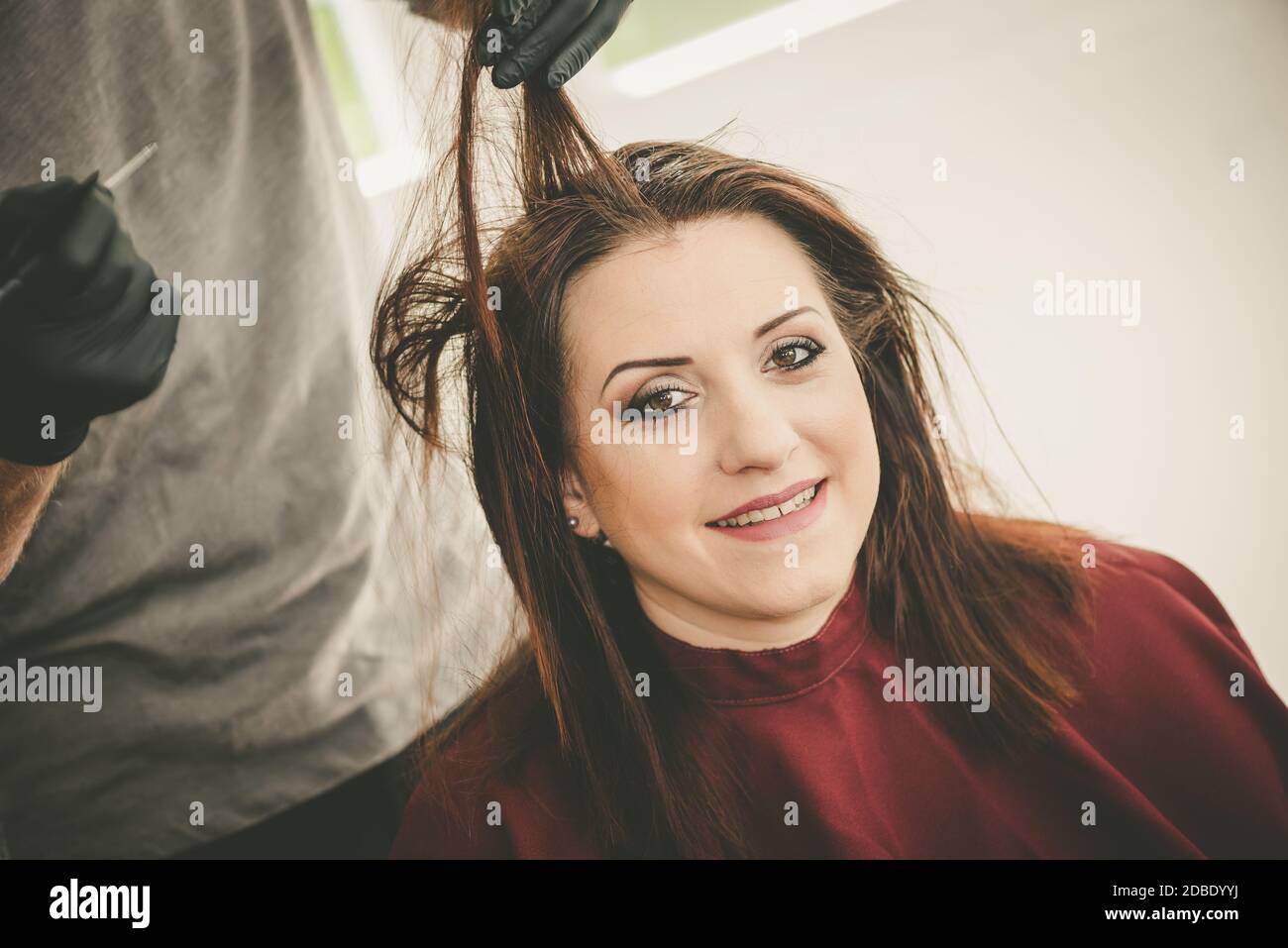 Hairdresser coloring female client hair Stock Photo - Alamy