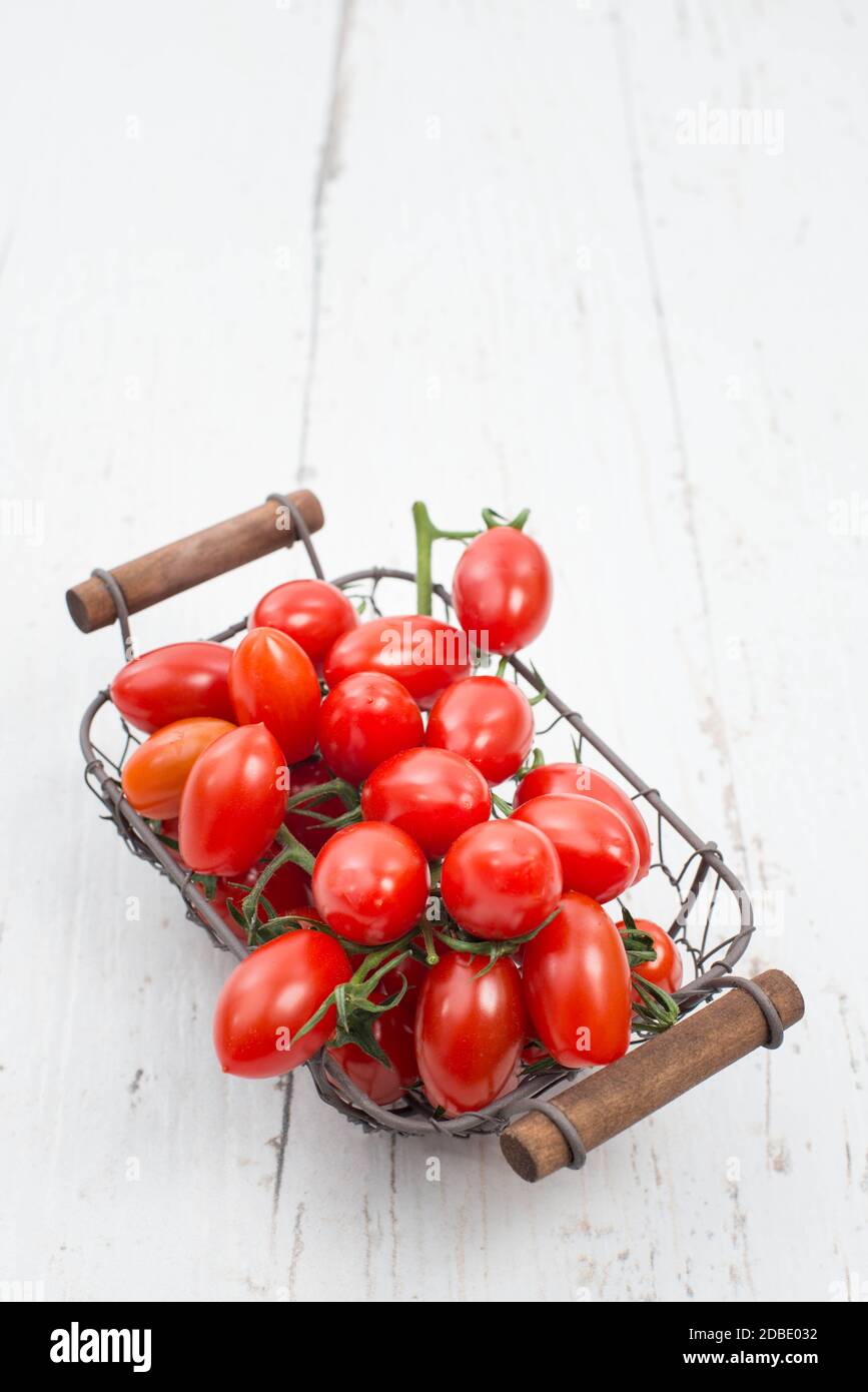 Red cherry tomatoes on a white shabby background, empty copy space ...