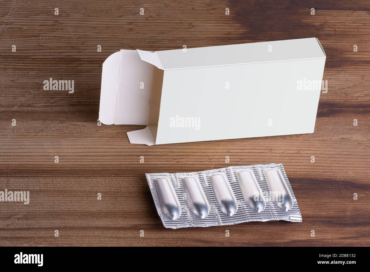 Suppositories loaf and an empty box on wooden table background ...