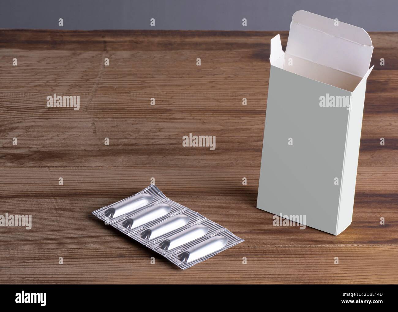 Suppositories loaf and empty box on wooden table background, mock up ...