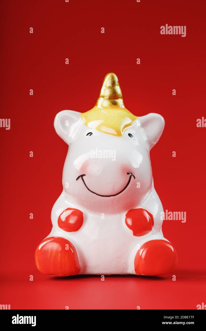 Unicorn figurine on a red background with free space. Symbol of good ...
