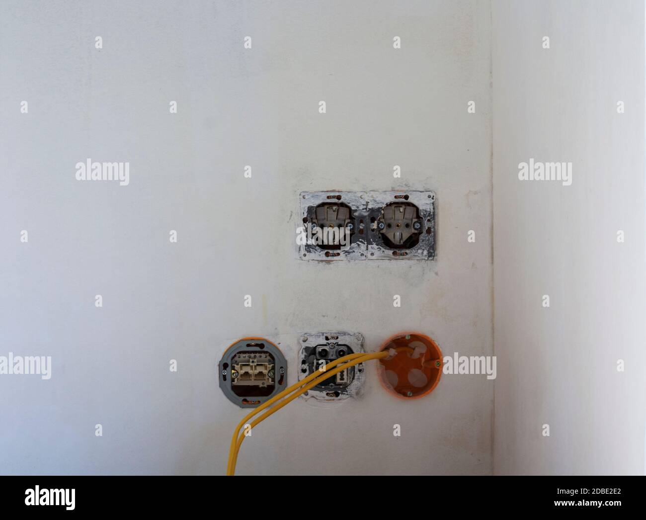 Sockets without cover on the wall, shortly after the wallpaper has been ...