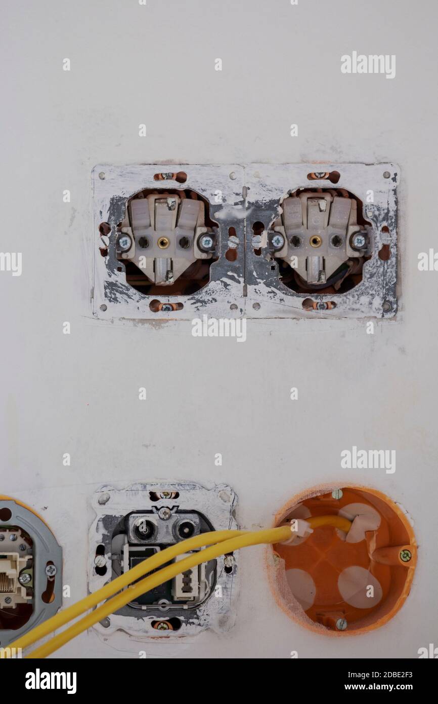 Sockets without cover on the wall, shortly after the wallpaper has been ...