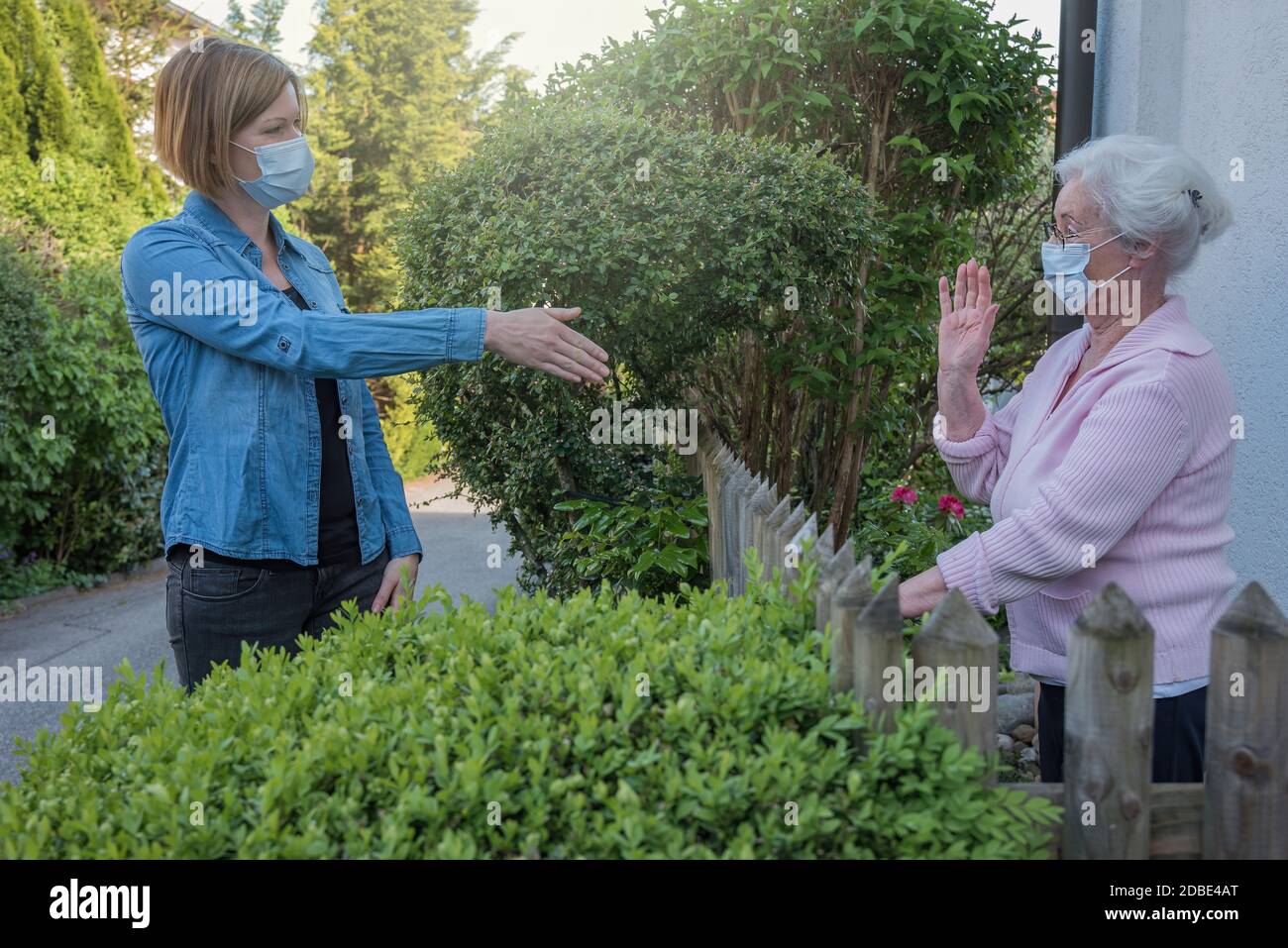 Senior woman with face mask shows safety distance to neighbor woman ...