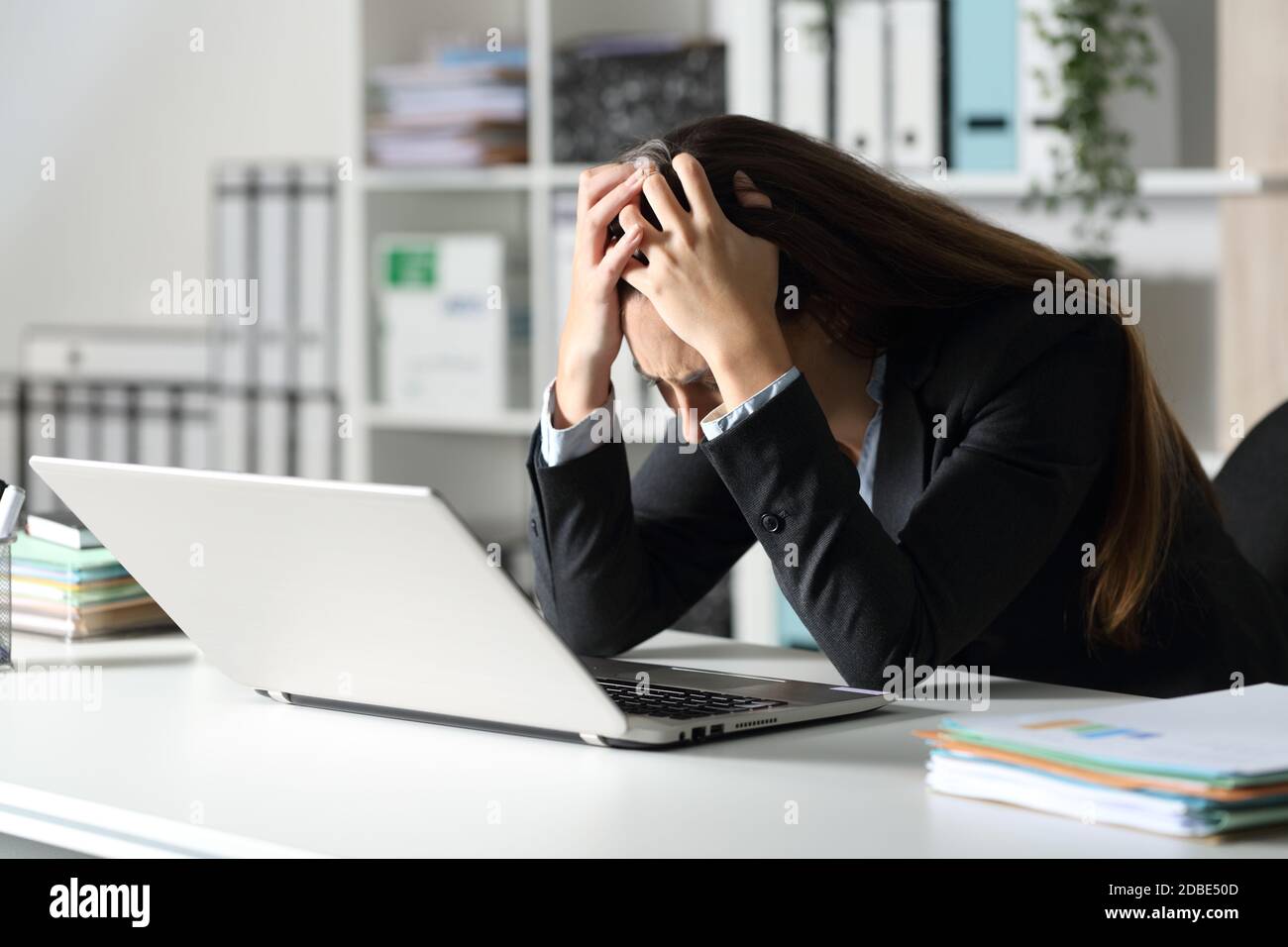 Sad executive woman with laptop complaining sitting on her desk at the ...