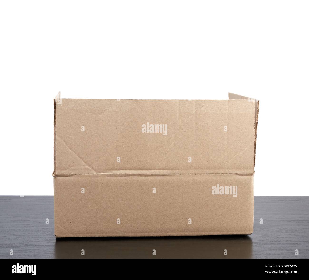 open cardboard box stands on a black table, white isolated background ...