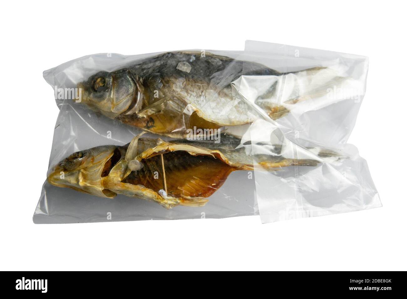 Dried salted crucian fishes in a transparent package isolated on white ...
