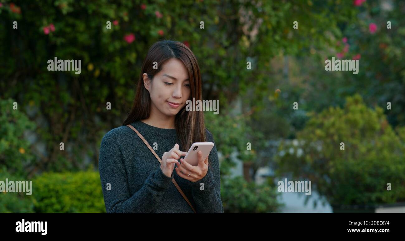 Chinese woman use of mobile phone at outdoor Stock Photo - Alamy