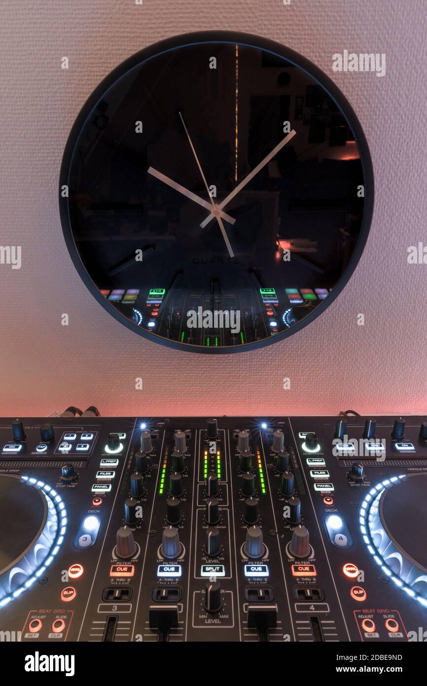 DJ Mixing Console in Front of a Deep Black Wall Clock Stock Photo - Alamy