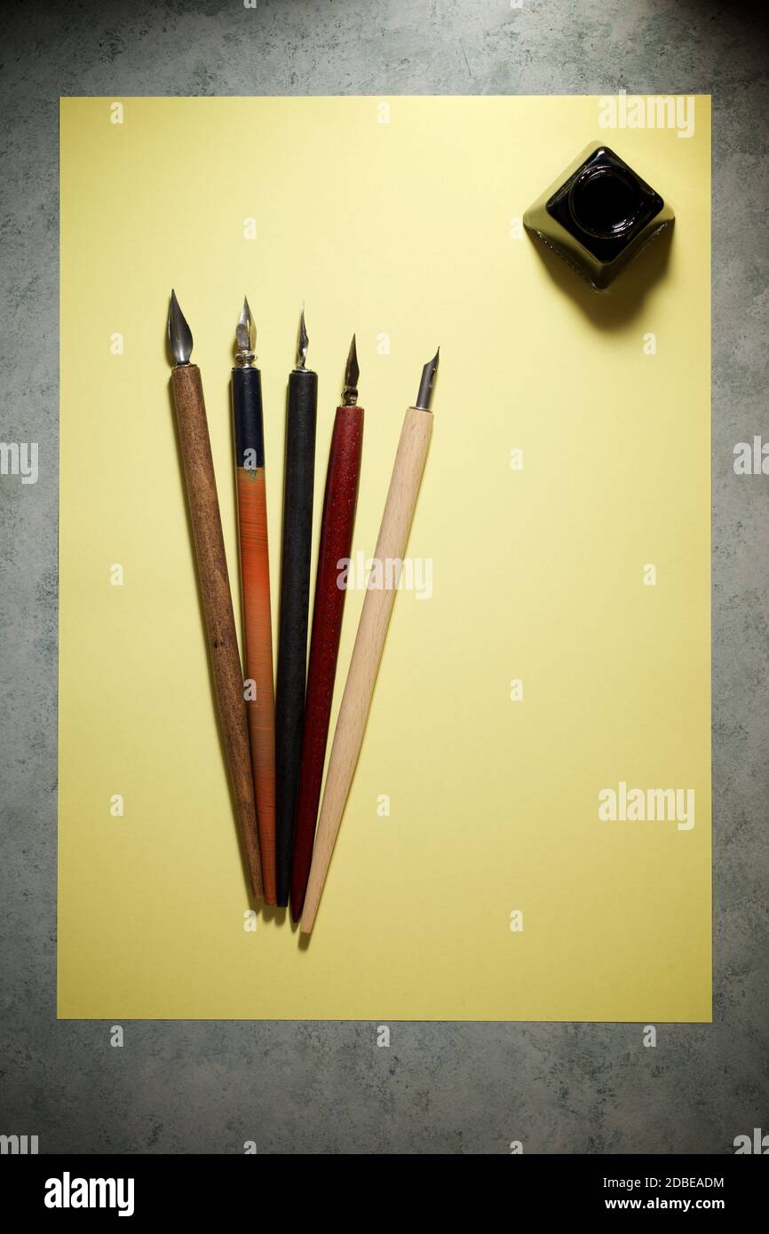 Nib pens for calligraphy and inkwell on a table Stock Photo - Alamy