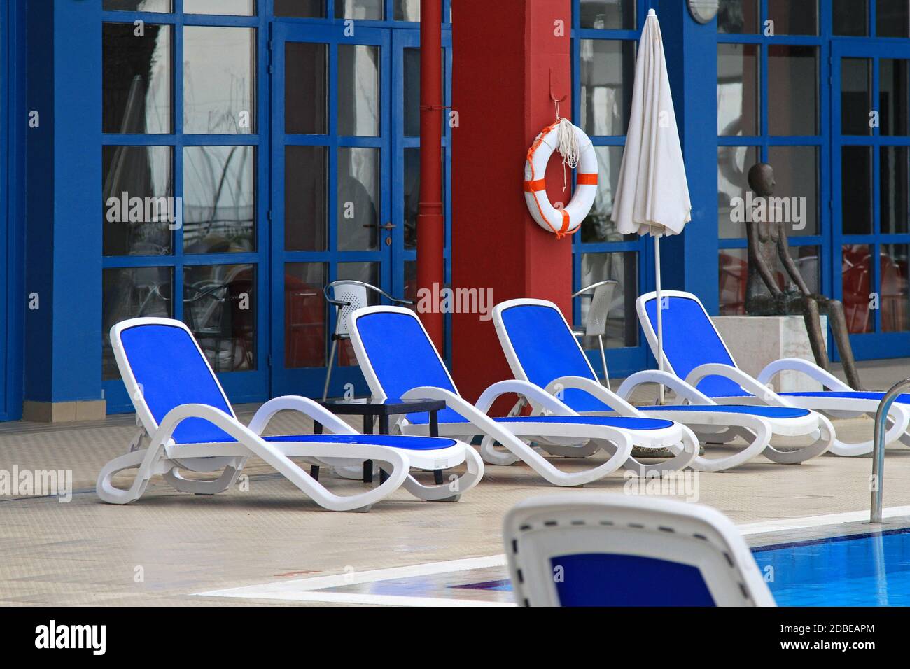 Deck chairs at sundeck near swimming pool Stock Photo - Alamy