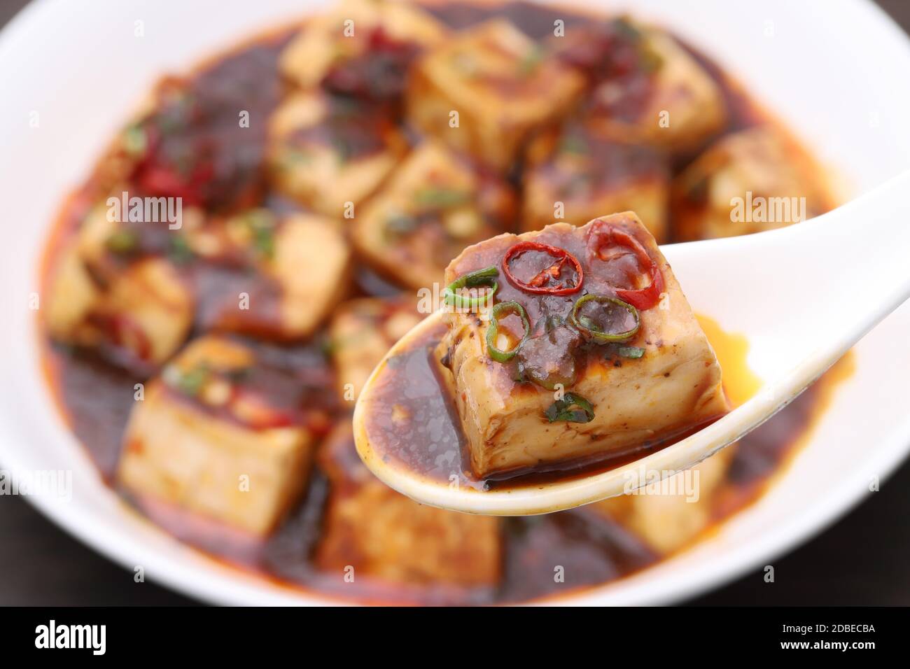Chinese cuisine mapo doufu in a dish with spoon Stock Photo - Alamy