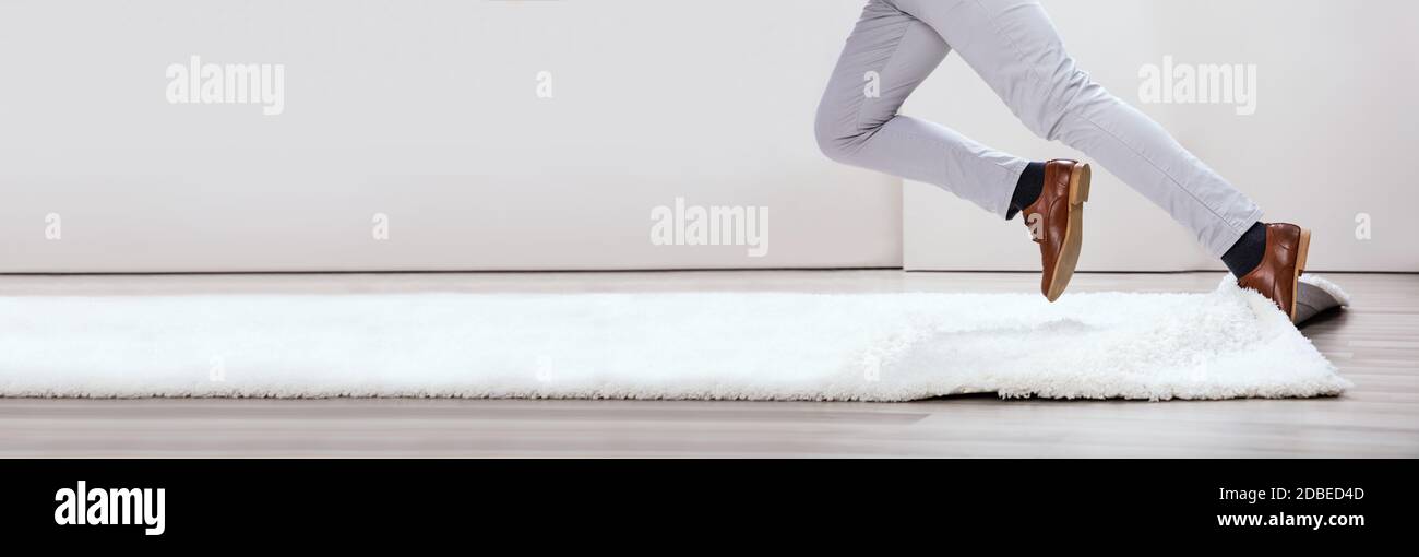Man Falling On Carpet At Home. Person Accident Stock Photo - Alamy