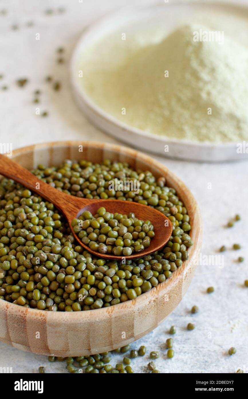 Mung beans flour and grain in bowls with a wooden spoon close up ...