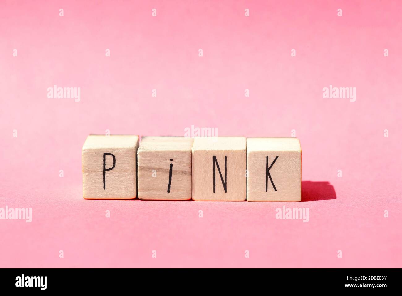 Wooden cubes lie in a row on pink background with the word Pink, Pastel ...