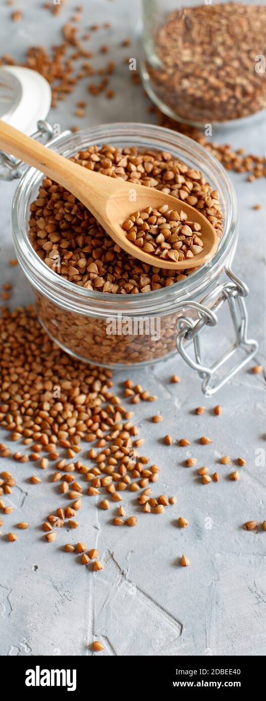 Raw dry buckwheat grain in a jar with a spoon close up Stock Photo - Alamy