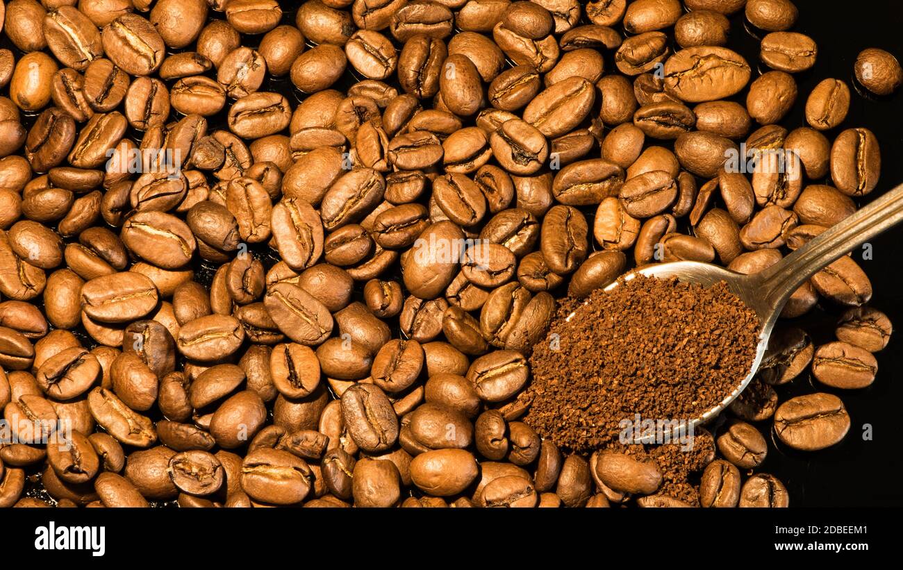 Coffee beans close-up with a spoon of ground coffee on a mirror ...