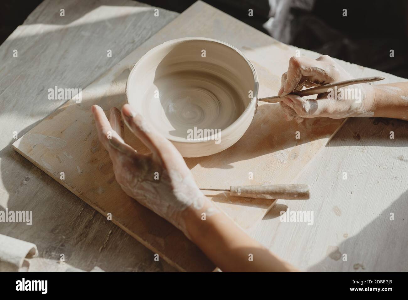Hands of potter creating an earthen bowl on the table. Close up Stock ...