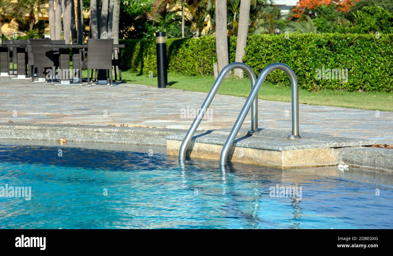 Grab bars ladder in the blue swimming pool Stock Photo - Alamy