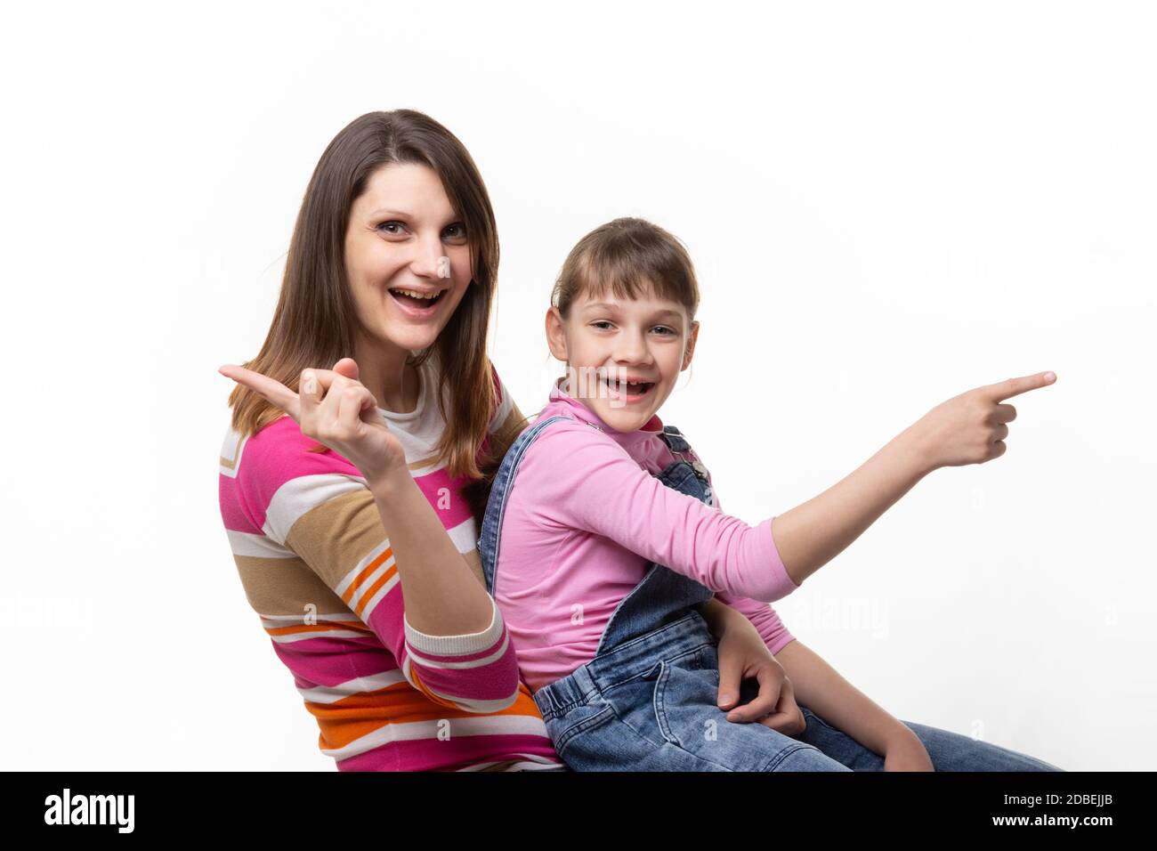 Joyful mom and daughter point finger in different directions, isolated ...