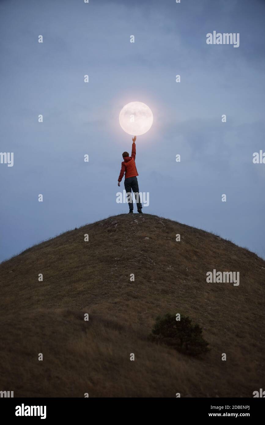Man reaching the full moon Stock Photo - Alamy