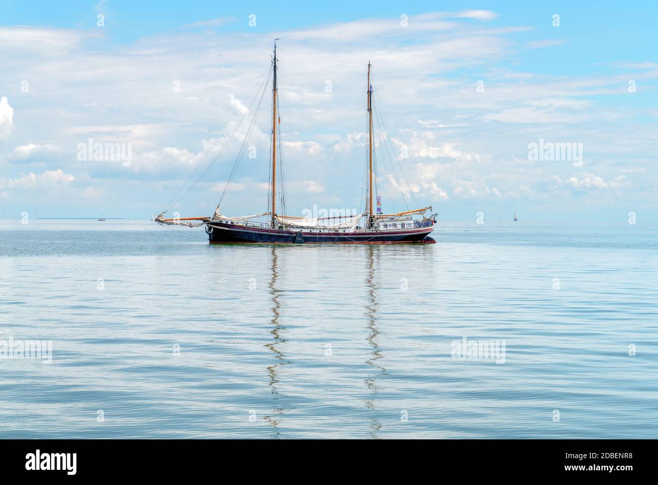 A two-masted ship is reflected on the surface of the water at sea Stock ...