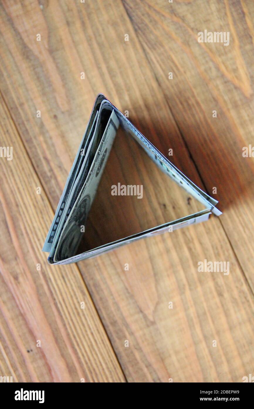 Hundred dollar notes on wooden boards. Hundred dollar bills folded in ...