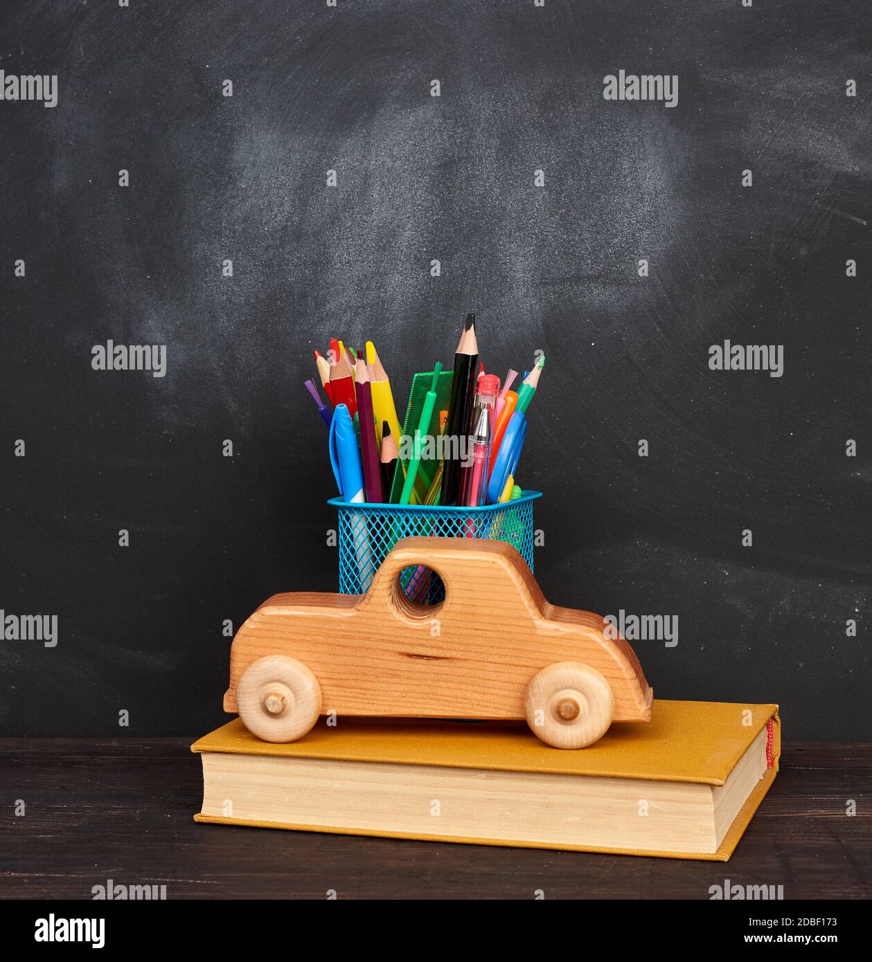 wooden toy, book, multicolored pens and pencils and other stationery in ...