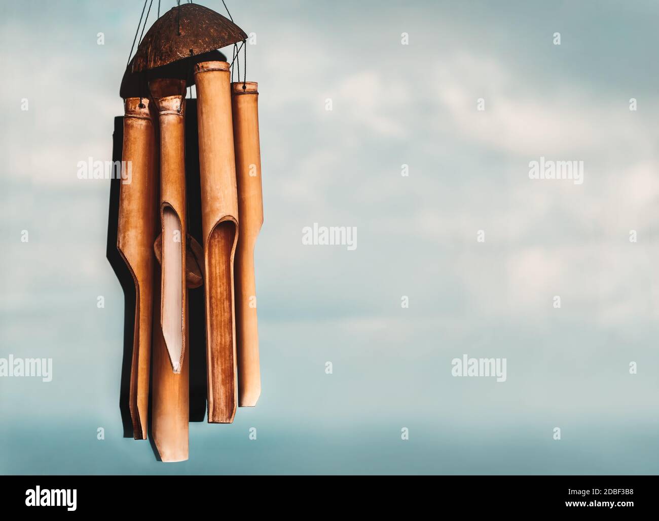 Wind chimes, bamboo wind bells over cloudy sky background, decor of ...