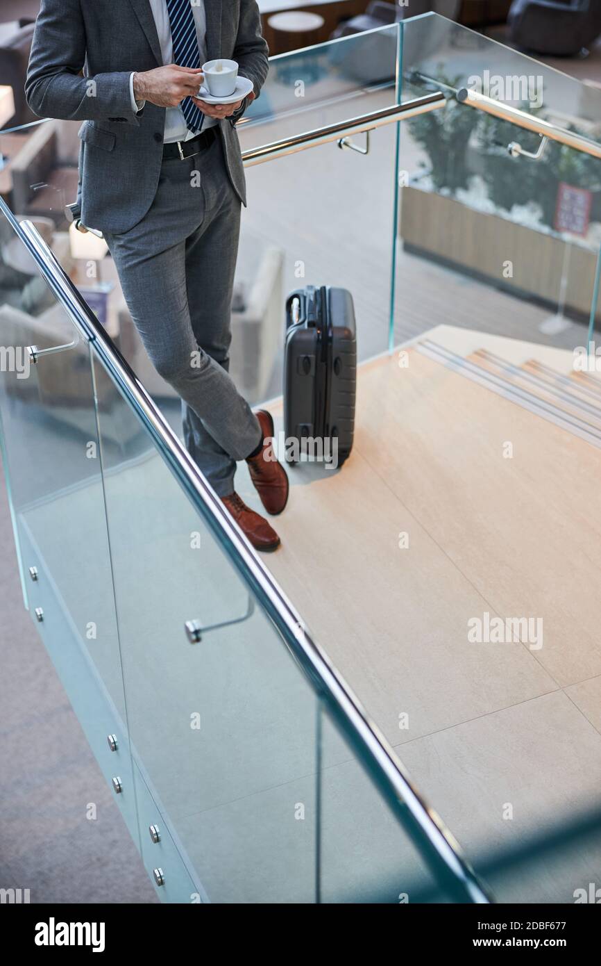 Entrepreneur with coffee throwing one leg over the other Stock Photo ...