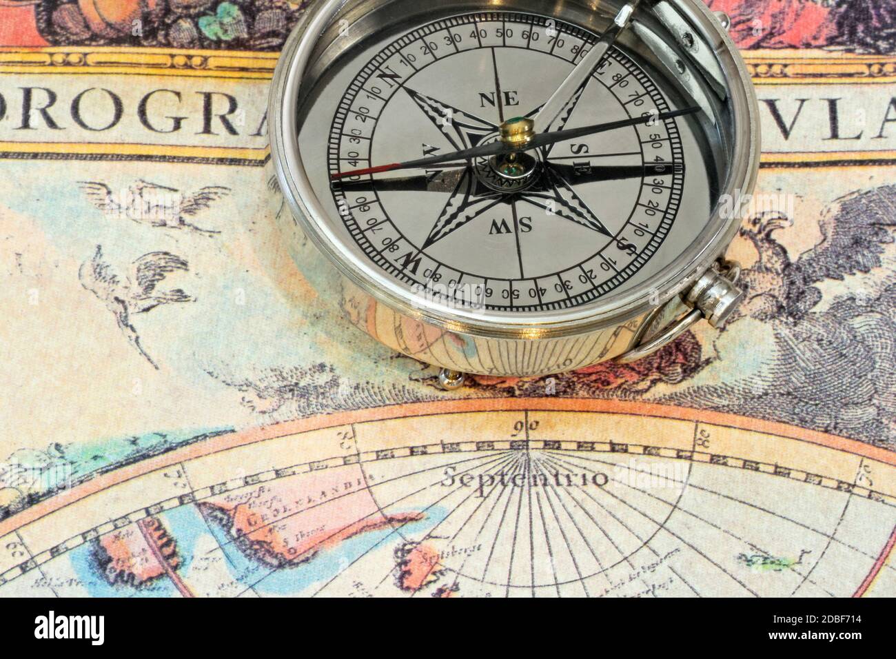 Silver metal compass on the old map Stock Photo - Alamy