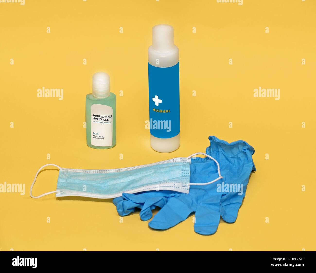 Alcohol and gel sanitizer containers with face mask and rubber gloves ...