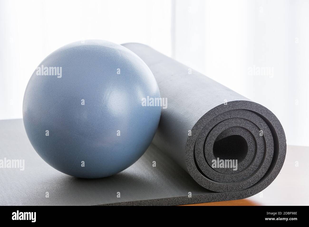 A blue ball and a grey pilates mat, with a back light and a wooden ...